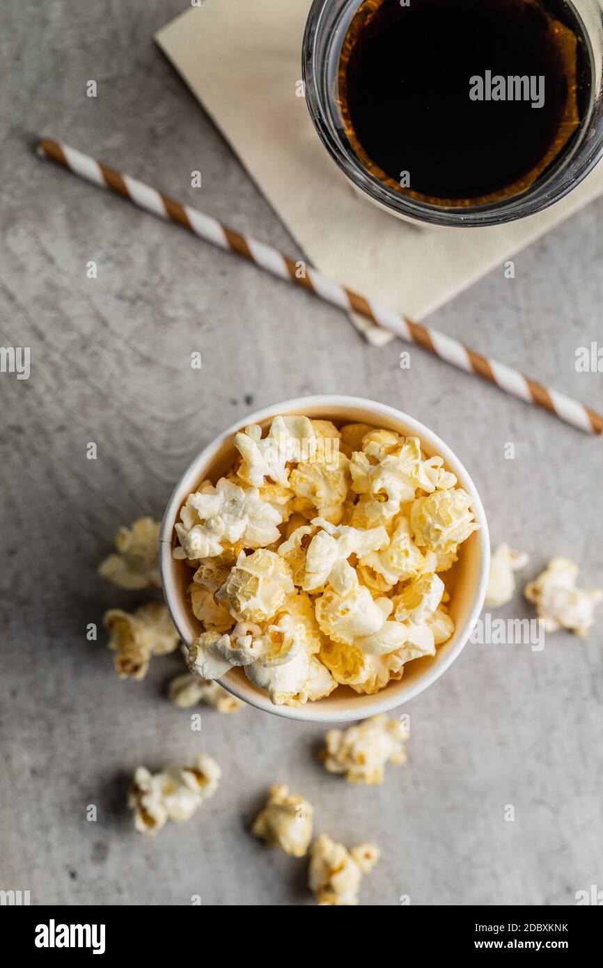 Sweet tasty popcorn in cup and glass of cola. Top view Stock Photo - Alamy