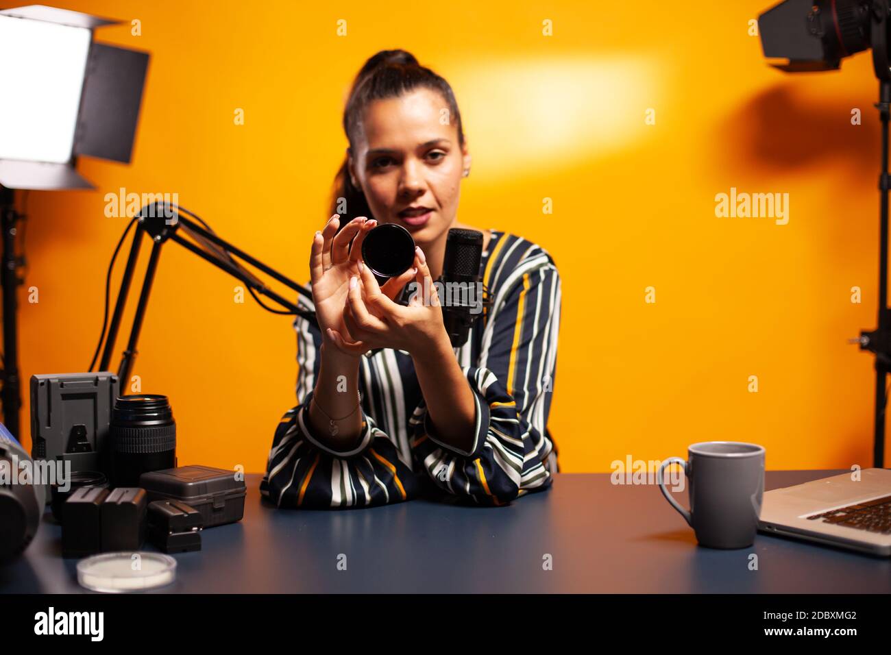 Woman vlogger reviewing round nd filter for camera lens. New media star ...