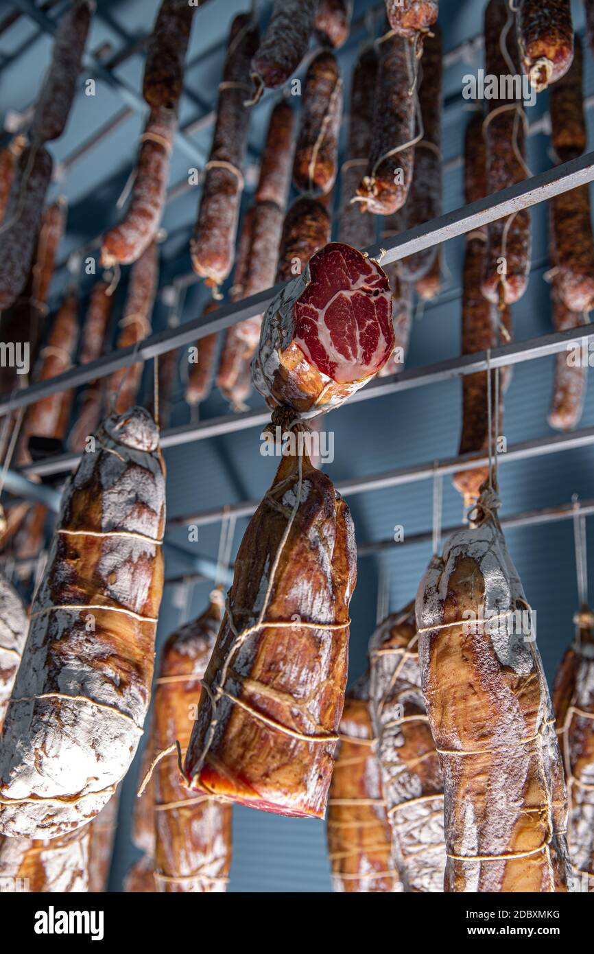Many smoked sausages and pork ham hanging on the drying chamber Stock ...