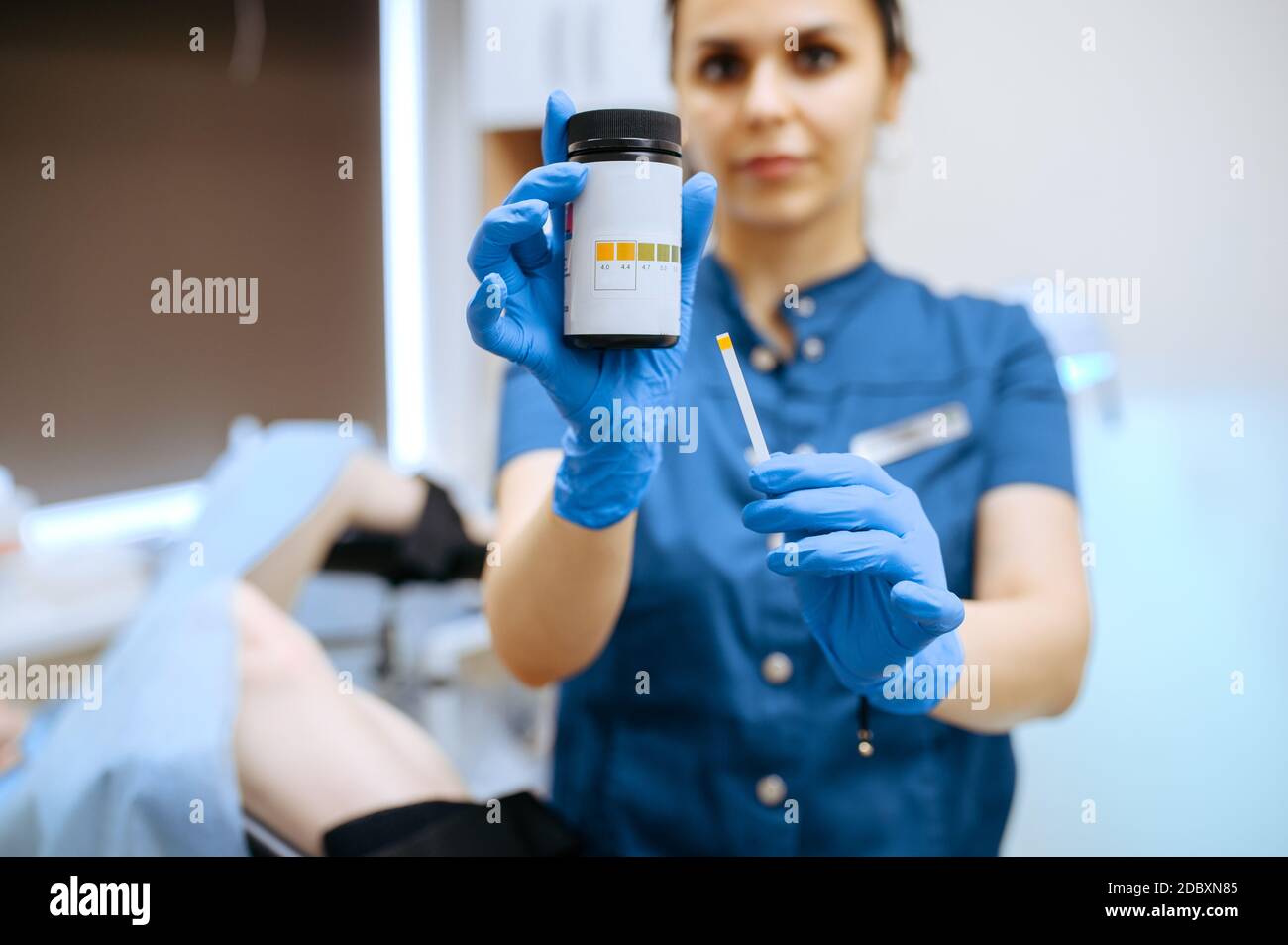 Female gynecologist in gloves and uniform shows tester. Gynecological ...