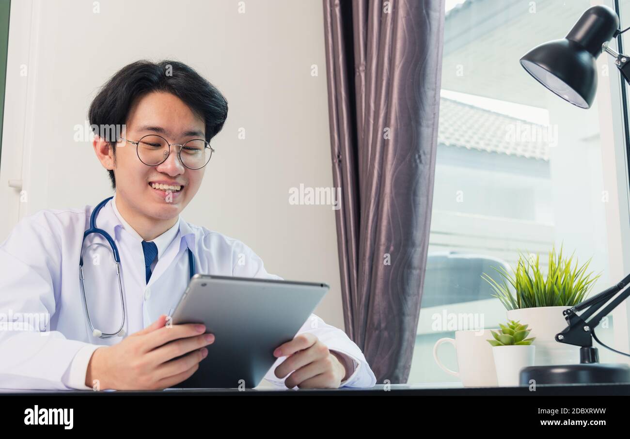 Happy Asian young doctor handsome man smile work from home office wear ...