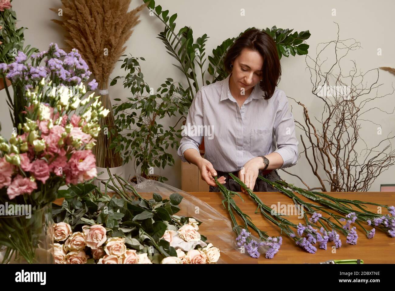 young woman florist in her studio makes a beautiful bouquet. Working moments Selective focus ...
