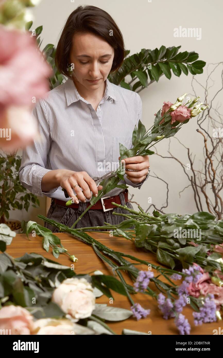 young woman florist in her studio makes a beautiful bouquet. Working moments Selective focus ...