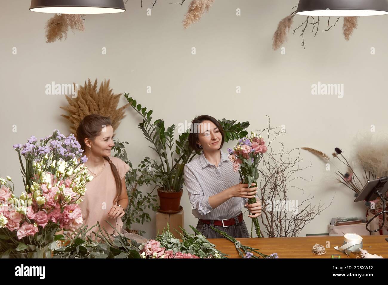 young women florist in her studio makes a beautiful bouquet. Working moments Selective focus ...