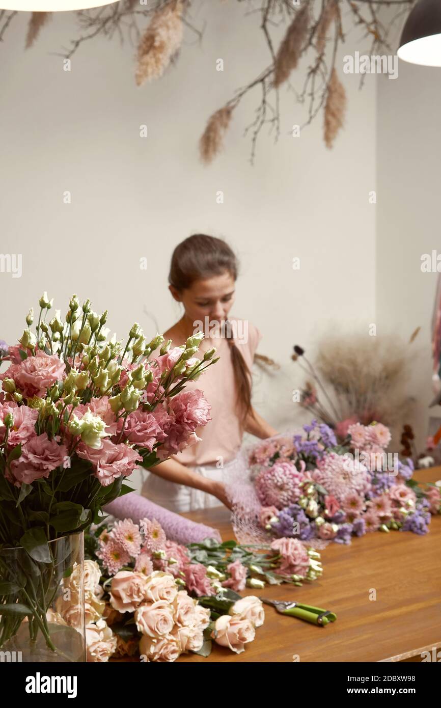 young woman florist in her studio makes a beautiful bouquet. Working moments Selective focus ...