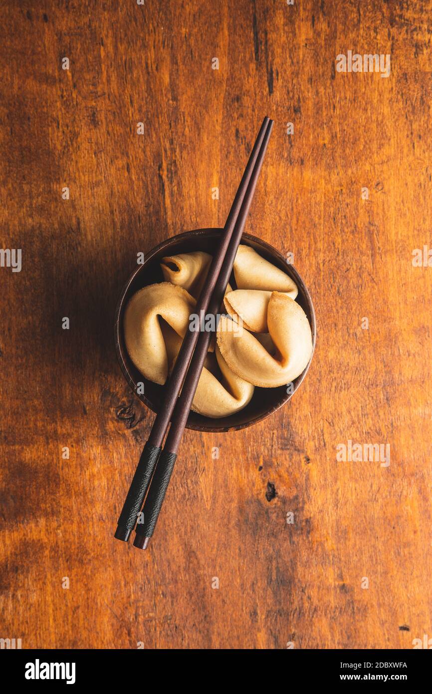 Chinese lucky cookies. Fortune cookies with chopsticks in wooden bowl ...