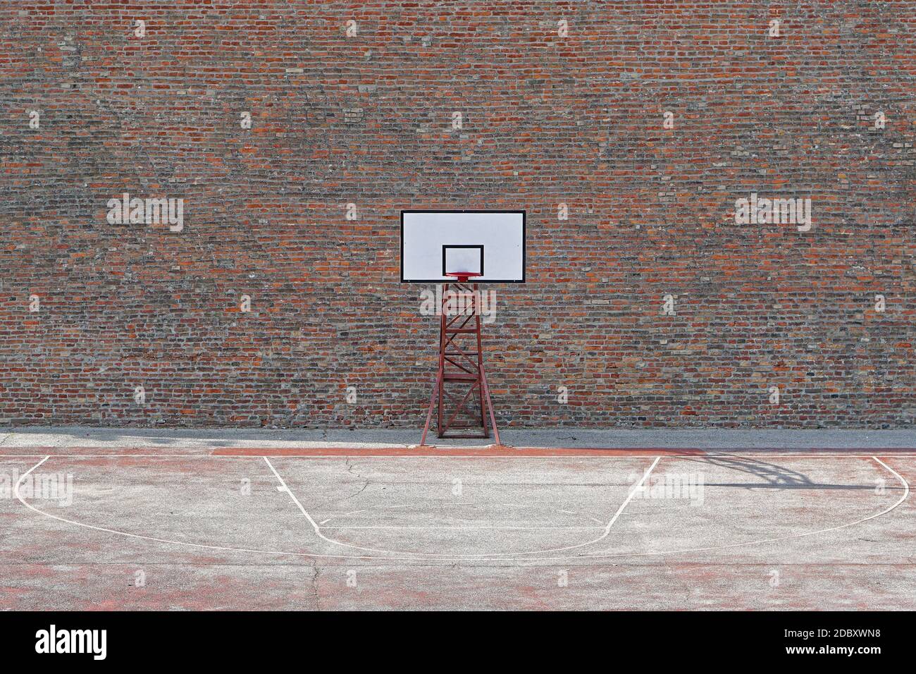 Basketball court with one hoop in front of brick wall Stock Photo - Alamy