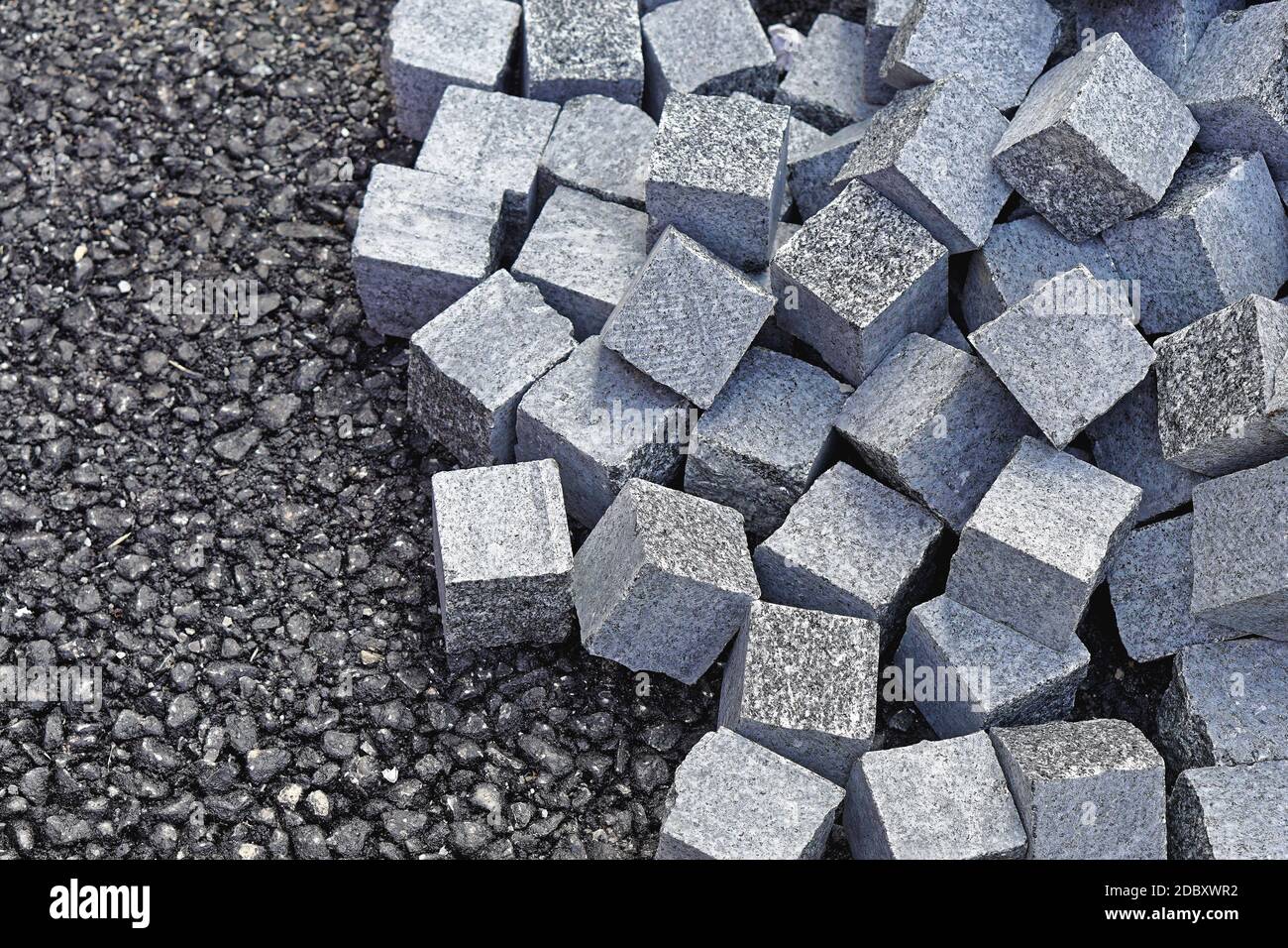 Big bunch of cobblestone bricks at new asphalt Stock Photo - Alamy