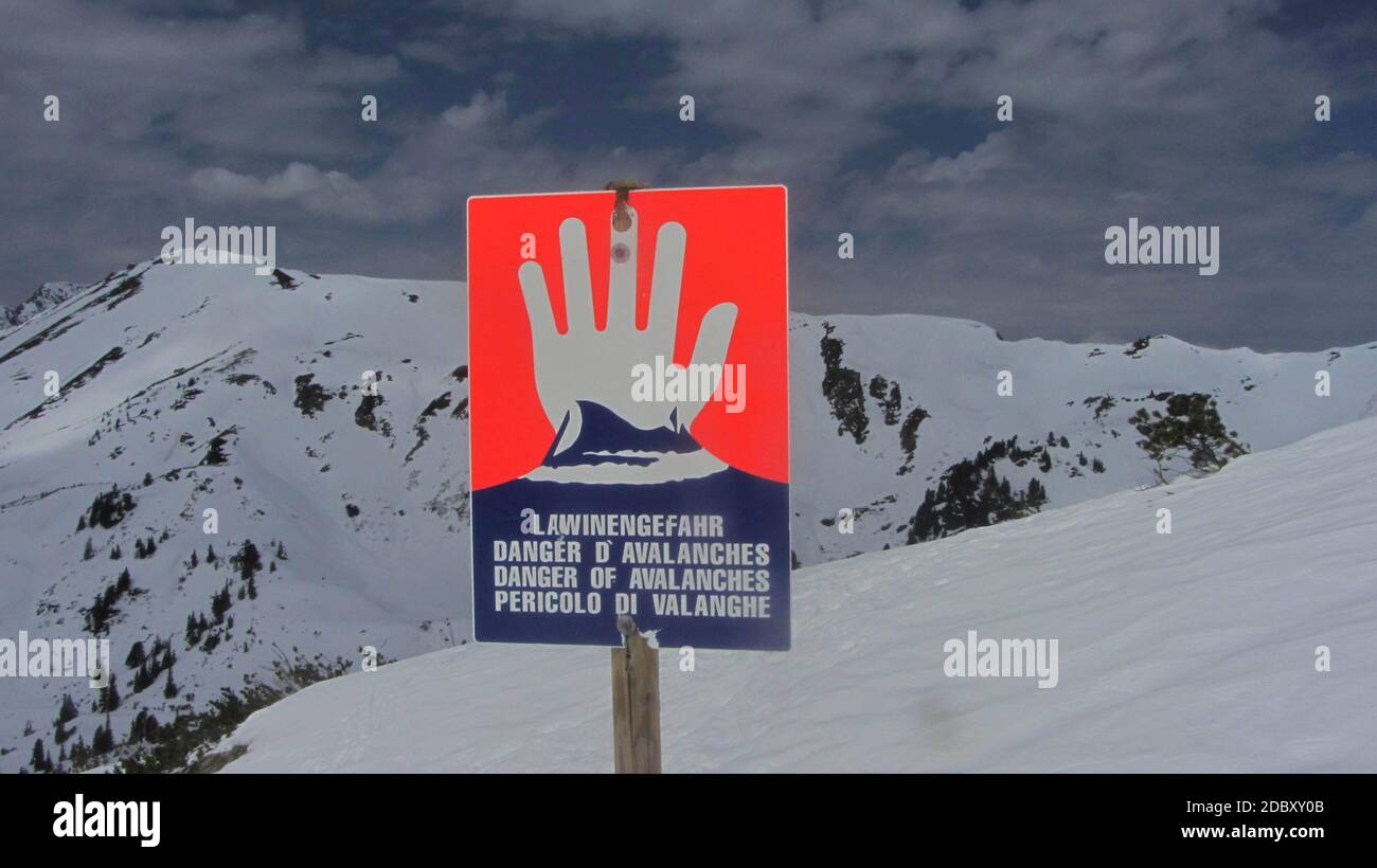 red danger of avalanches warning sign on snowy mountain - in german ...