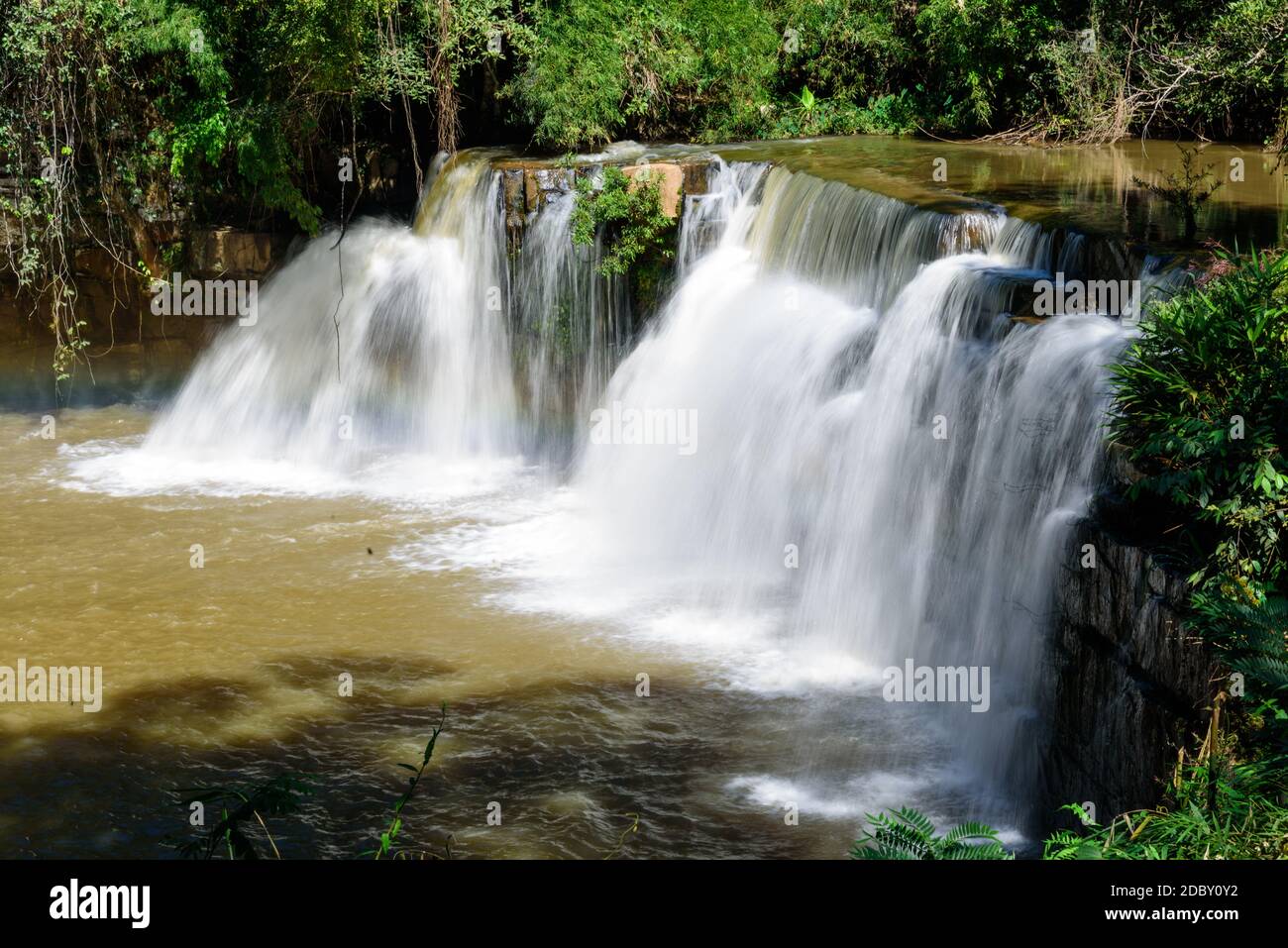 Big waterfall in forest with sunlight Stock Photo - Alamy
