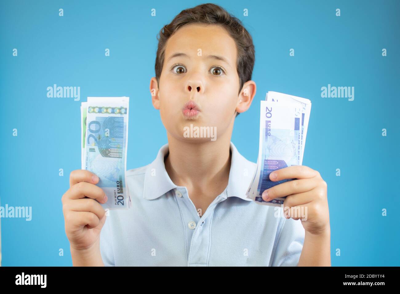 Surprised little boy with money cash. Cute kid hiding face behind fan ...