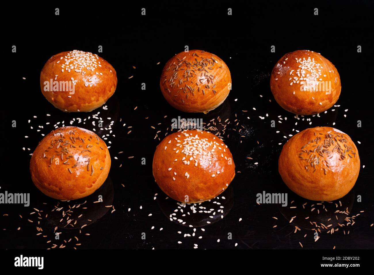 White crispy buns with sesame seeds. Photo on a black background ...