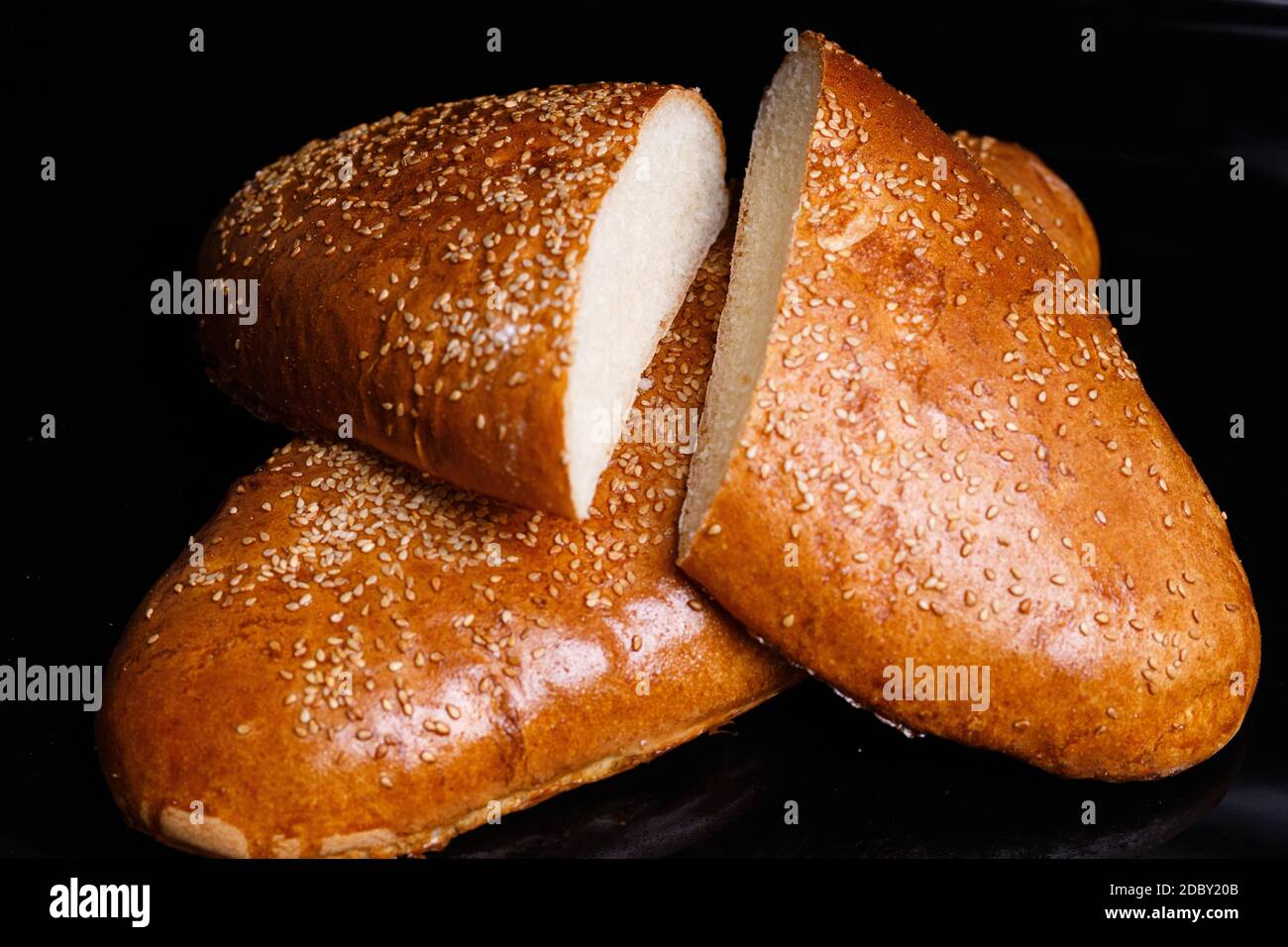 Homemade pastries. Crispy white bread cut with a knife. Photo on a black background Stock Photo ...