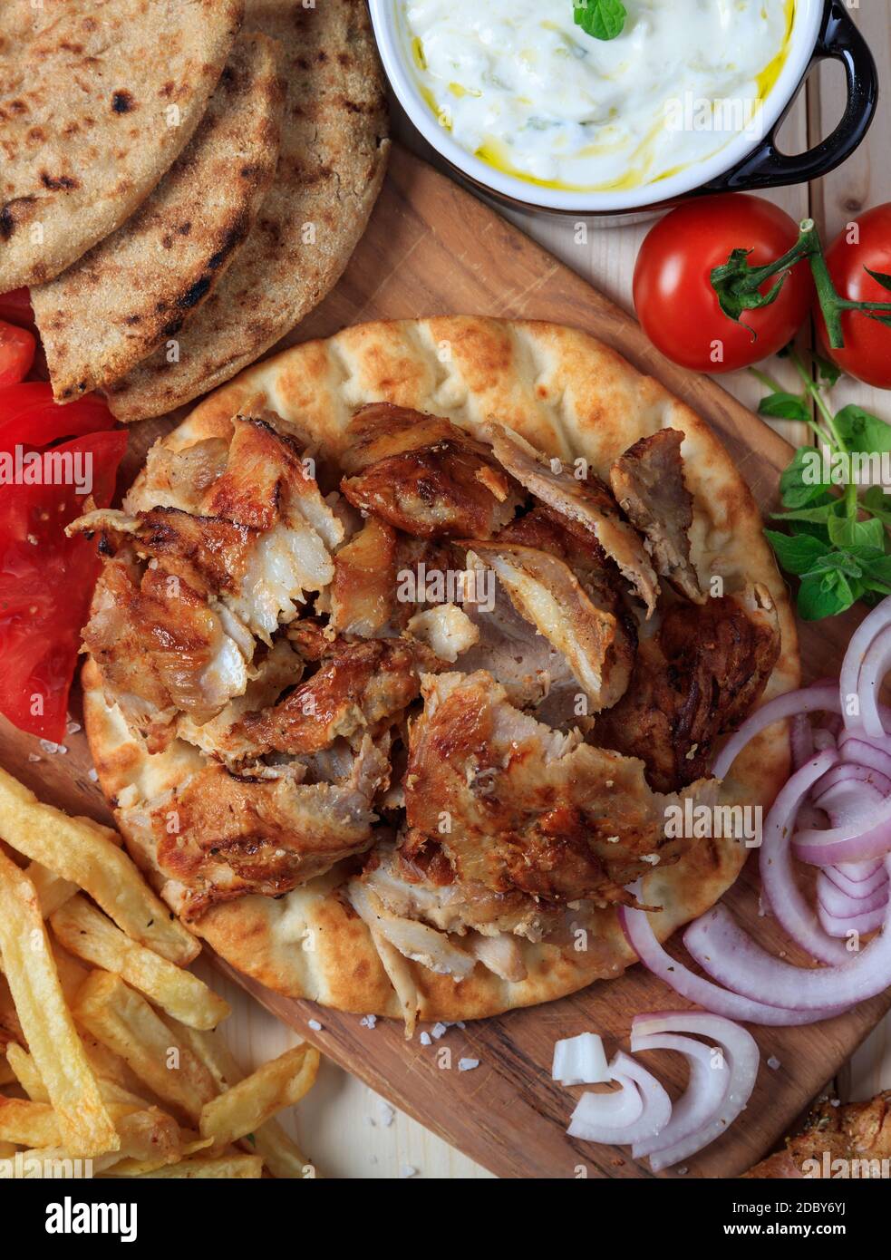 Gyro greek food. Grilled meat slices served with fried potatoes, tomato ...