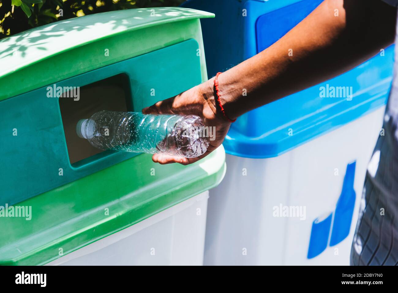 Selective focus close up the man black hand throwing an empty plastic water bottle in the ...