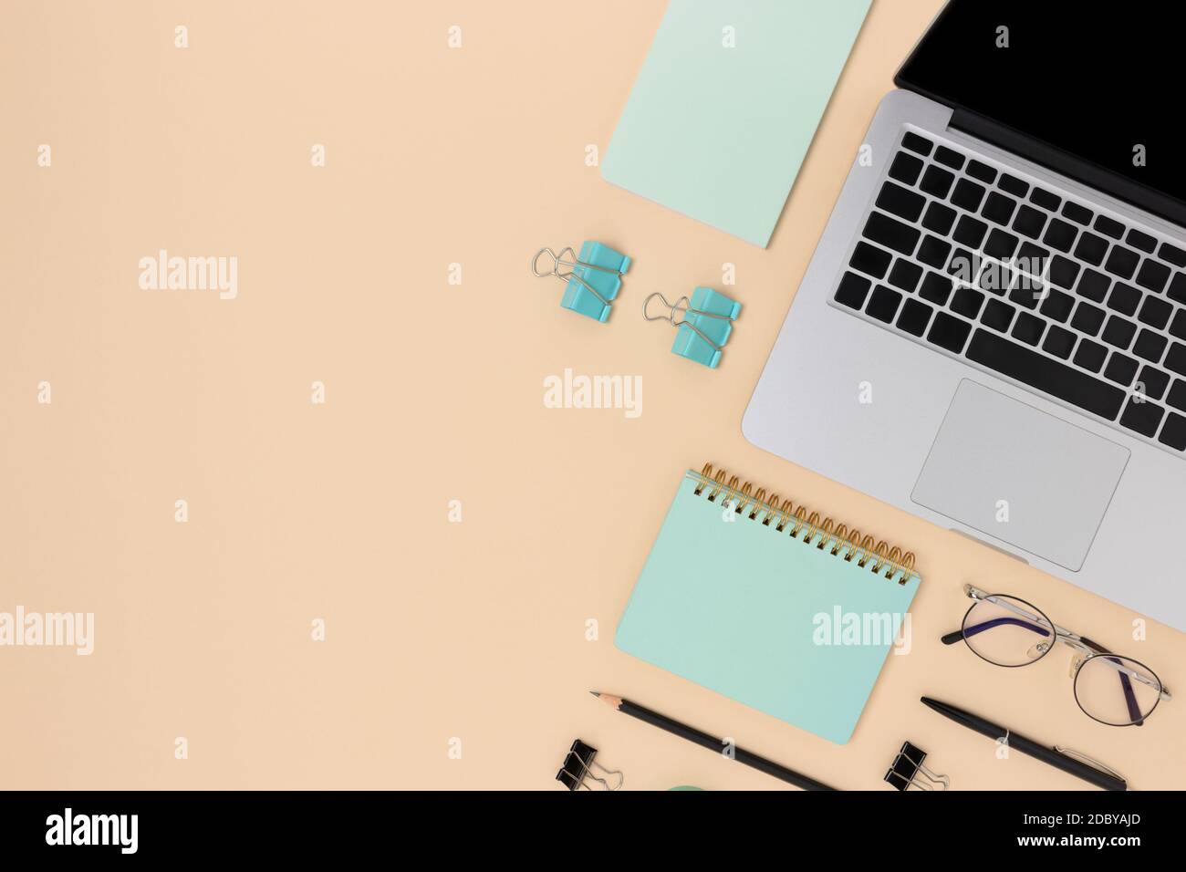 Workspace with laptop and office supplies on a beige background. Place ...