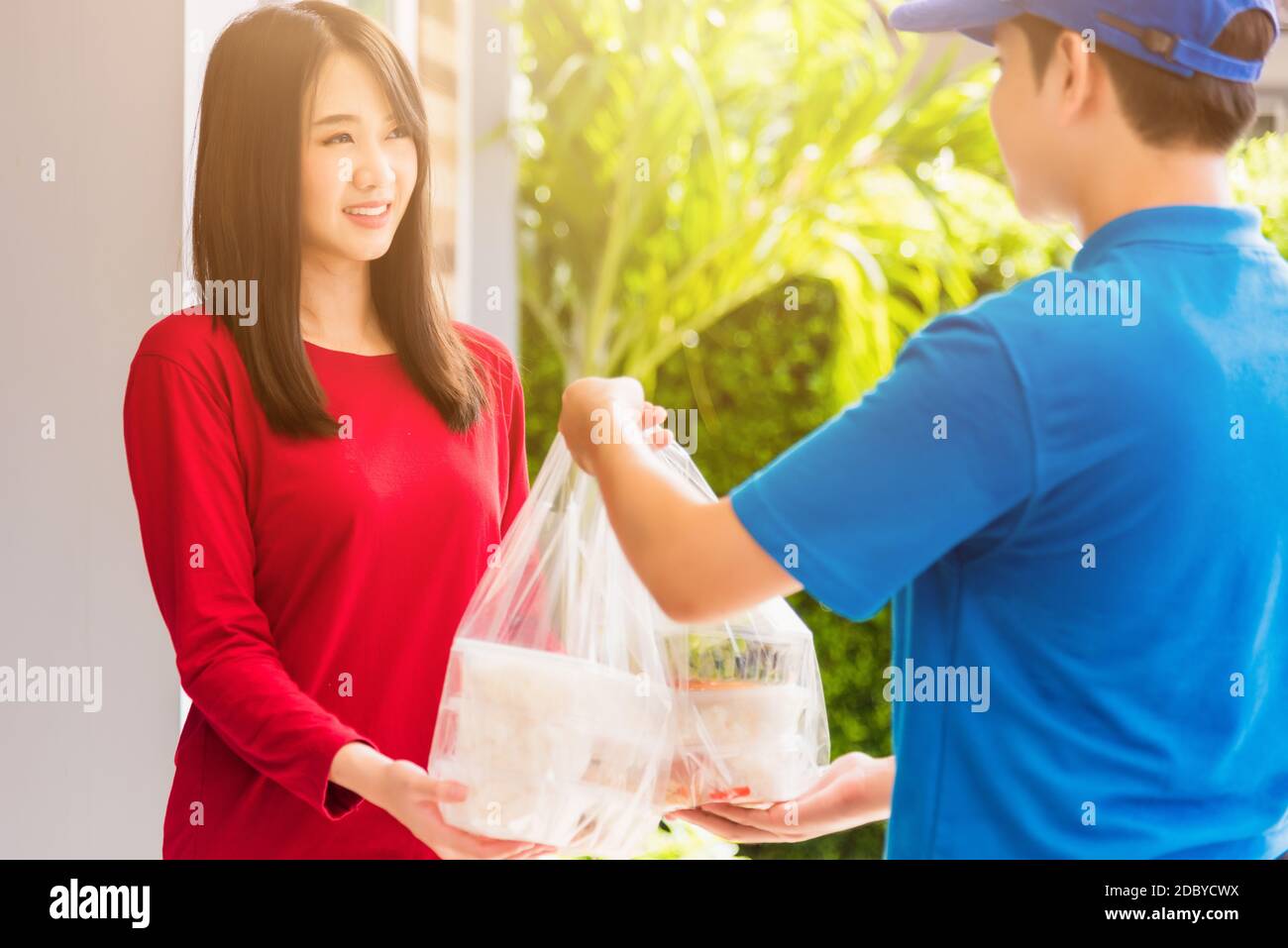 Asian young delivery man in blue uniform he making grocery service ...