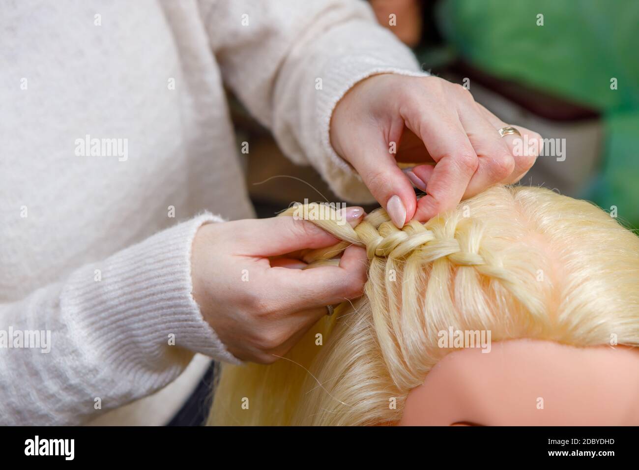 Professional braiding of braids by a master hairdresser in a beauty ...