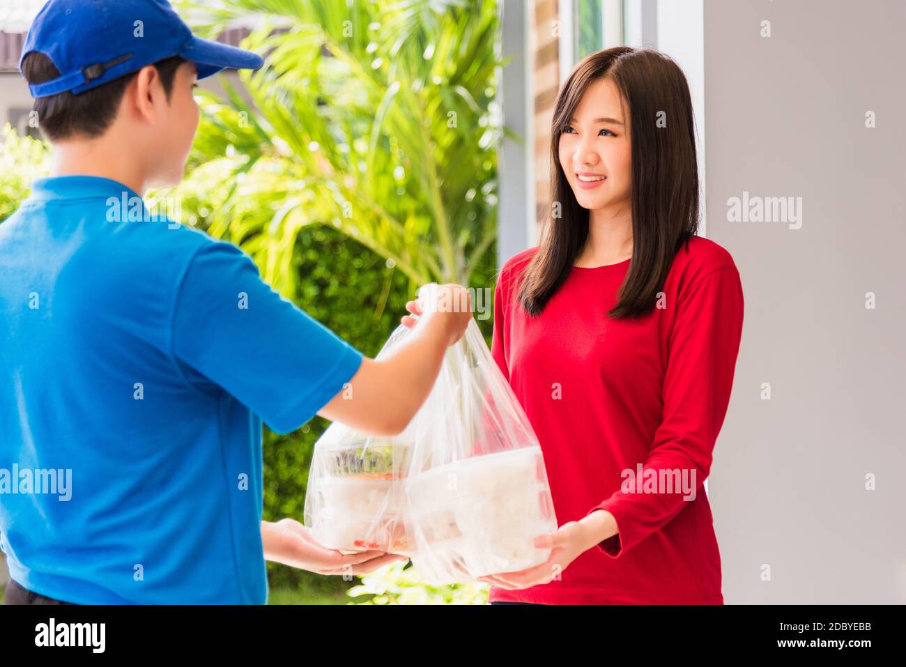 Asian young delivery man in blue uniform he making grocery service ...