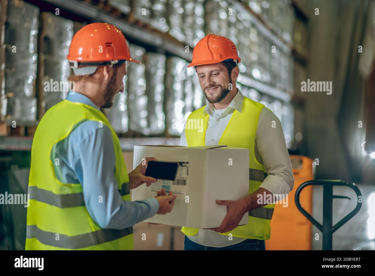 Two warehouse workers scanning barcodes from the containers Stock Photo ...