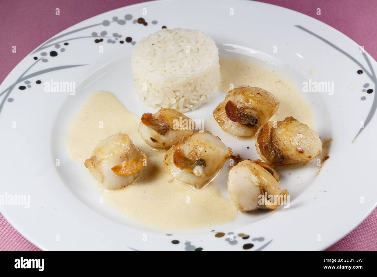 Plate of grilled scallops with rice and cream sauce Stock Photo - Alamy