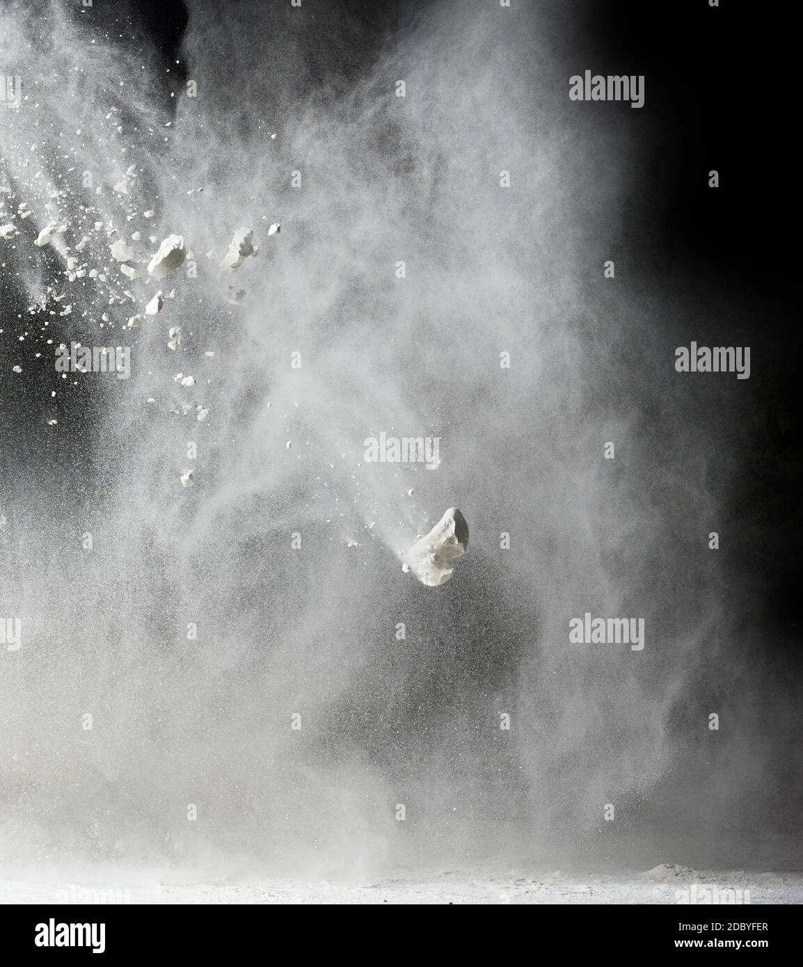 cloud of white wheat flour on a black background, particles fly in ...