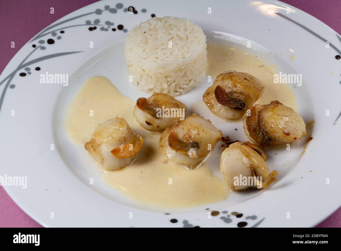 Plate of grilled scallops with rice and cream sauce Stock Photo - Alamy