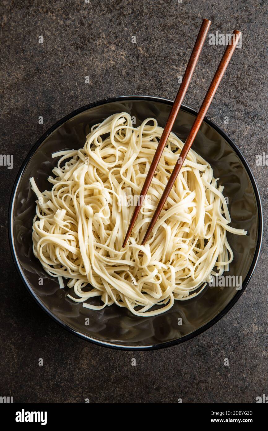 Cooked udon noodles. Traditional Japanese noodles in plate on black ...