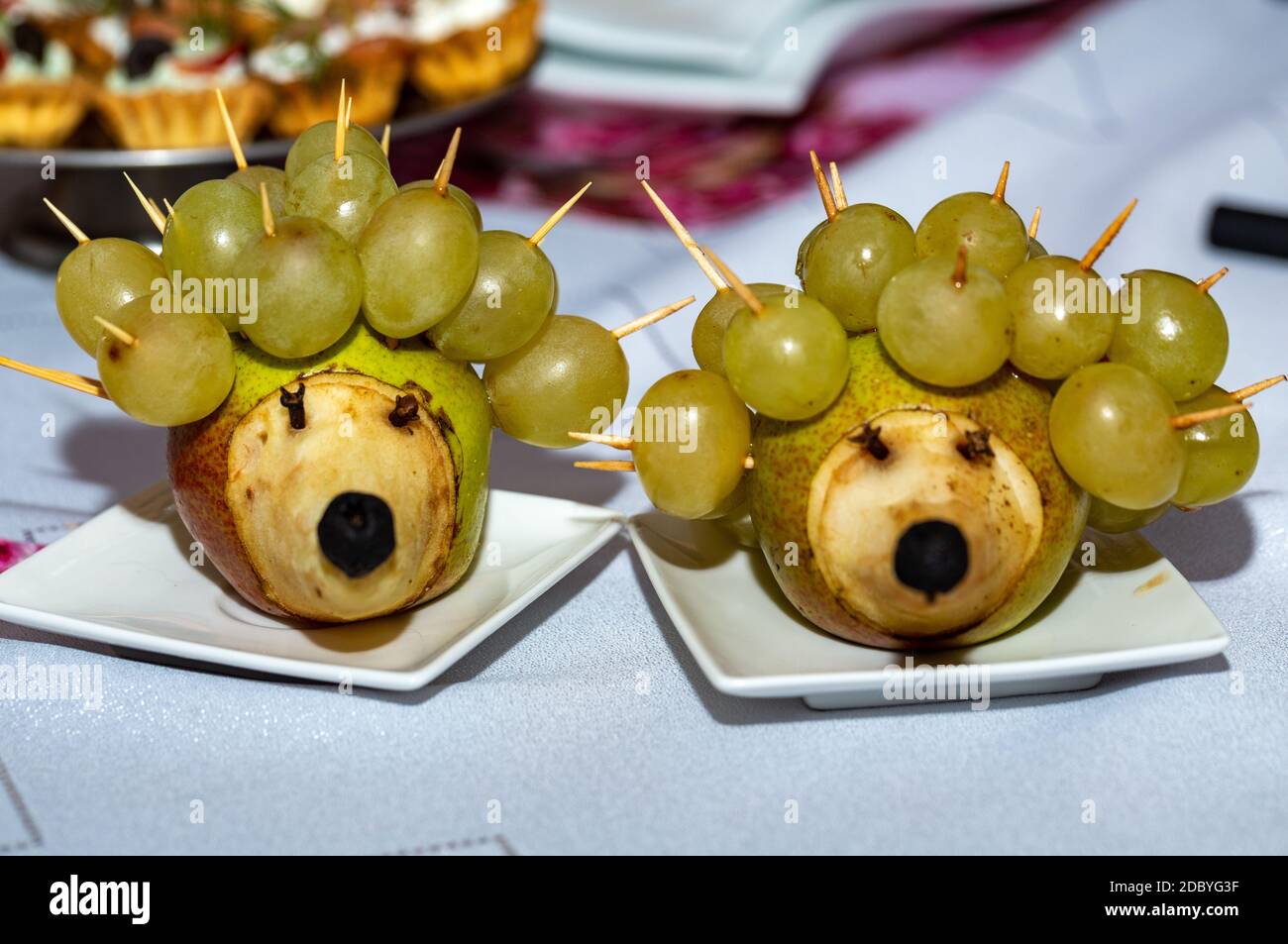 Fruit dessert. Hedgehog made of pears and grapes Stock Photo - Alamy