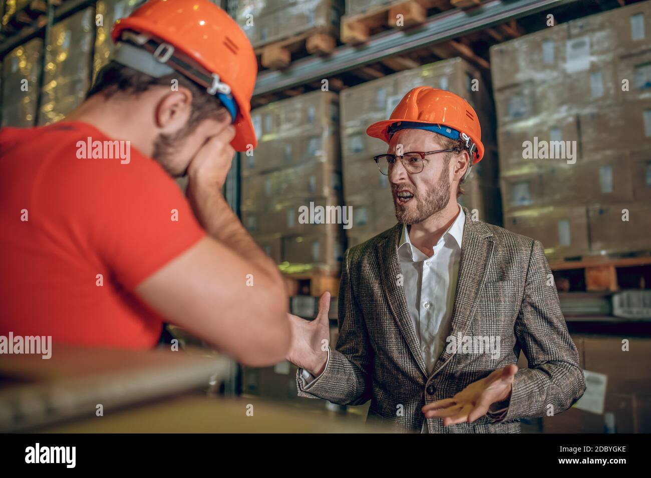 Manager having a tough conversation with the warehouse worker and ...