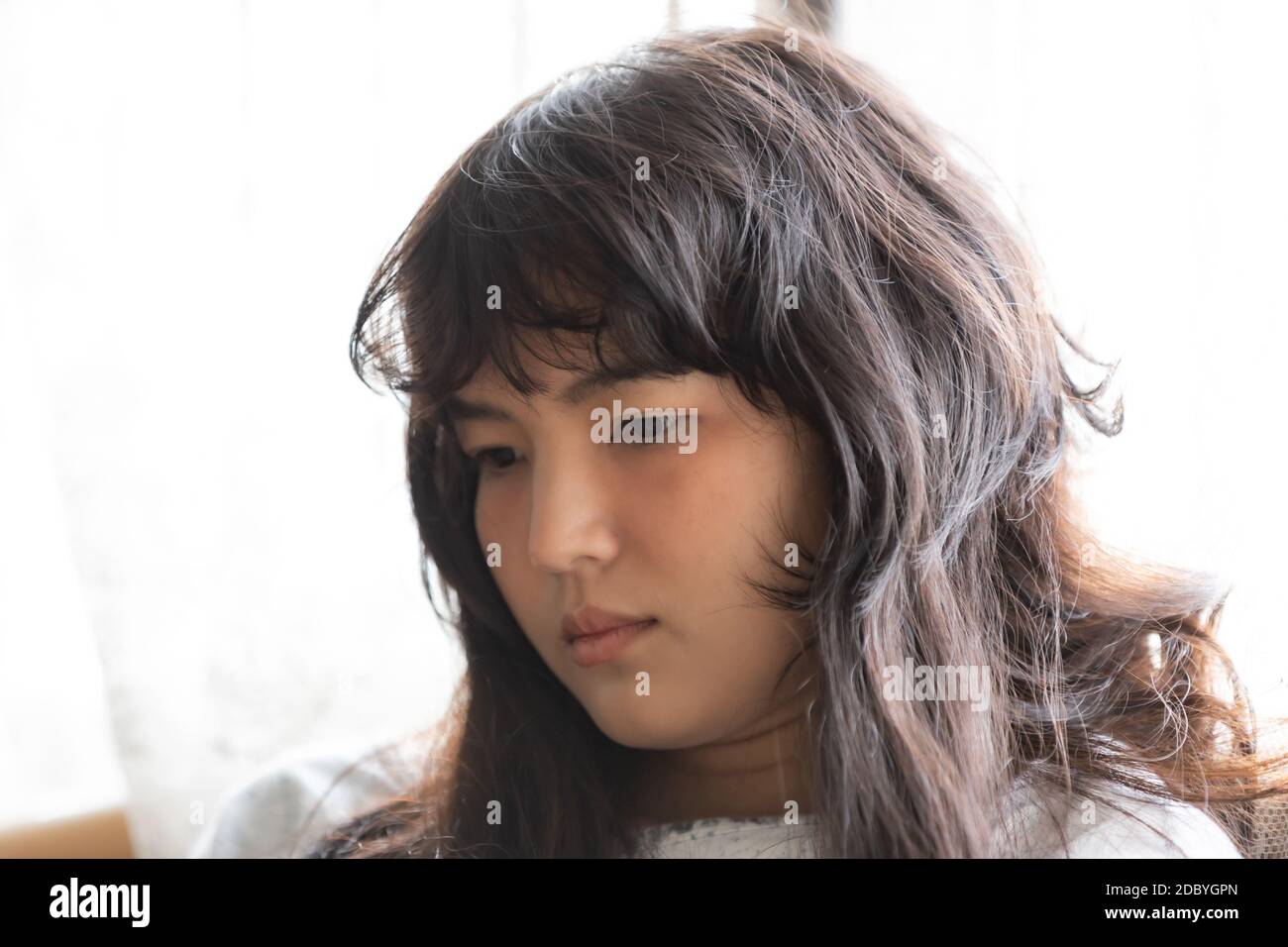 Young Asia girl sitting on the sofa feeling be absent-minded, Lonely ...