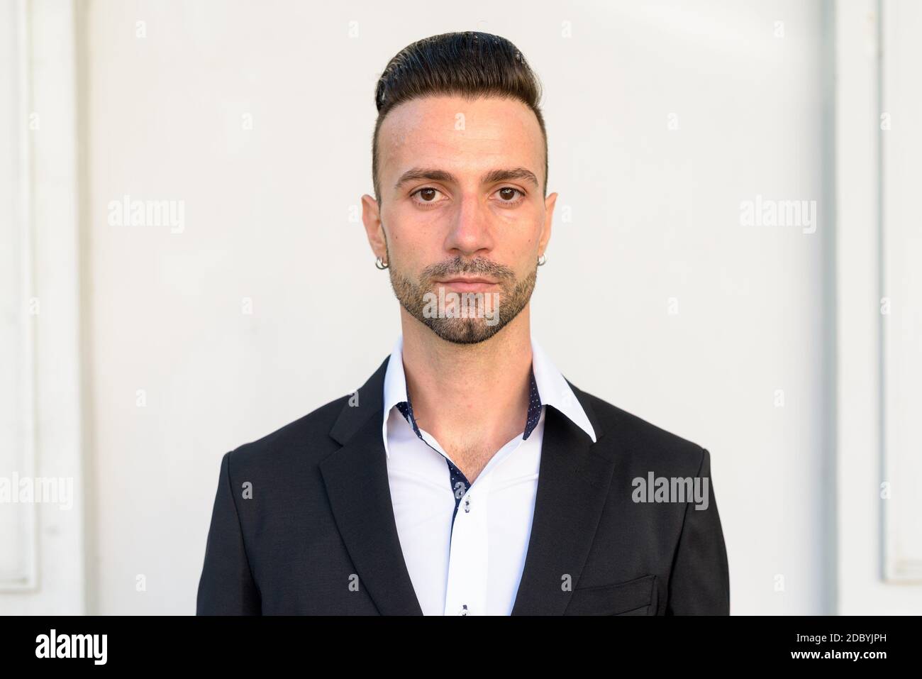 Portrait of handsome young businessman face against white wall Stock ...