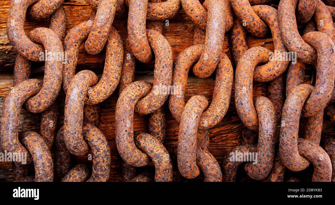 Rusty chains wound round a wooden cylinder Stock Photo - Alamy