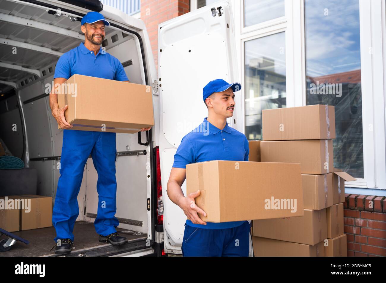 Truck Movers Loading Van Carrying Boxes And Moving House Stock Photo ...