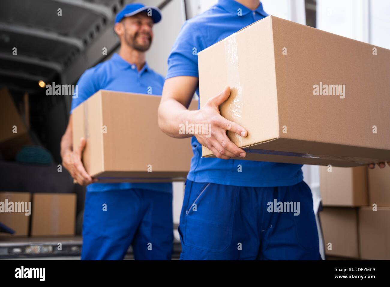 Delivery man carrying boxes on a hand truck hi-res stock photography ...