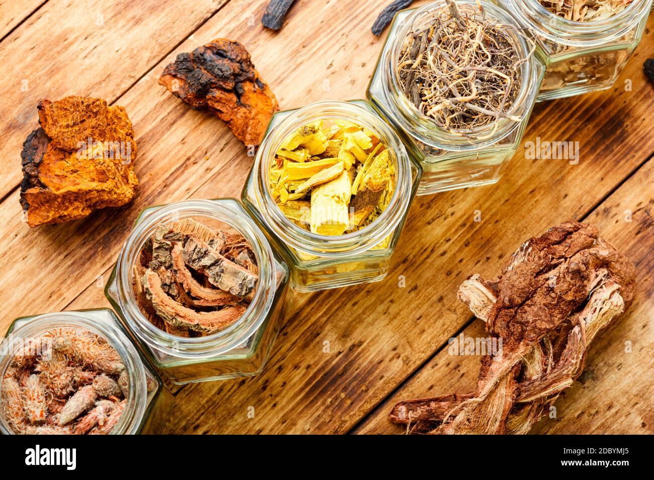 Large set of dried medicinal herbs,roots and bark on rustic wooden ...