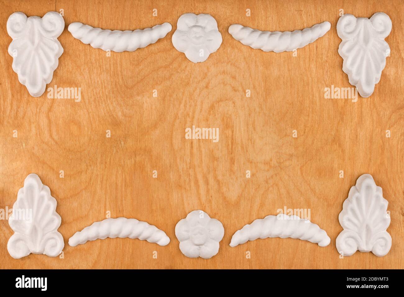 Luxury frame made of white stucco plaster, lying on a light wood, with ...