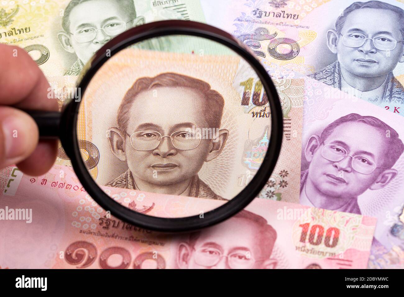 Thai money in a magnifying glass Stock Photo - Alamy