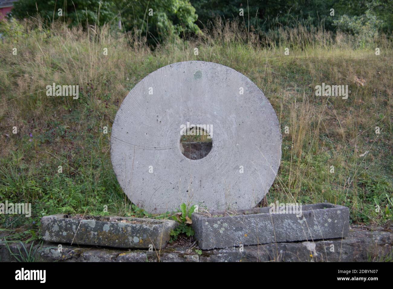 heavy stone mill wheel stands in the grass Stock Photo - Alamy