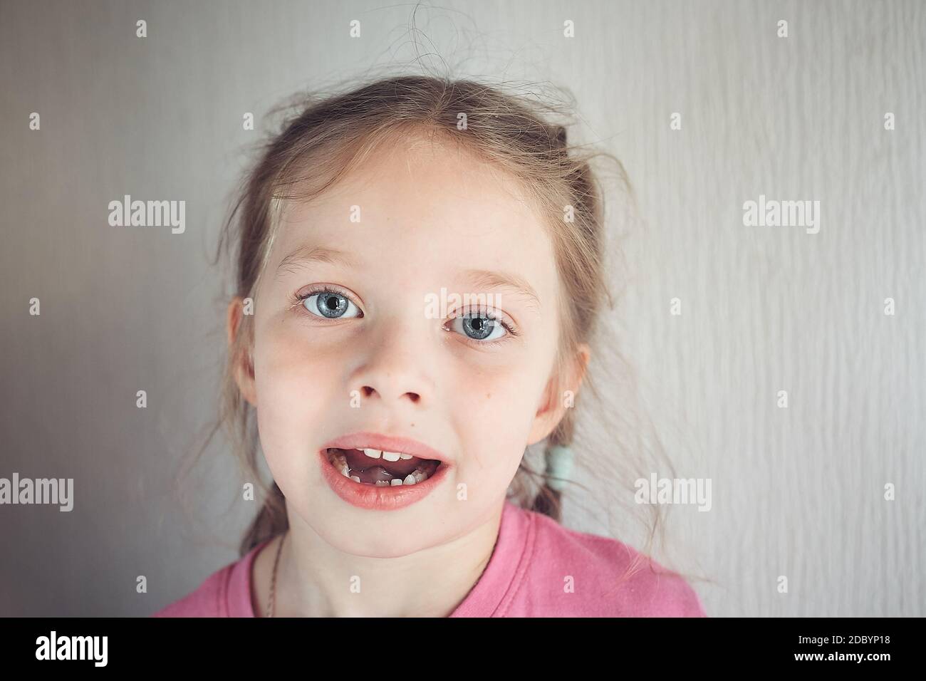 first baby teeth that fell out, portrait of a girl with her front teeth ...