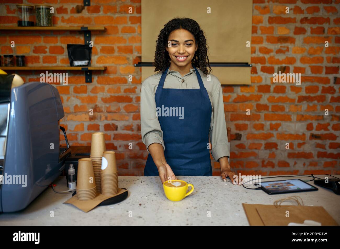 Female barista in apron prepares aroma coffee in cafe. Woman makes ...