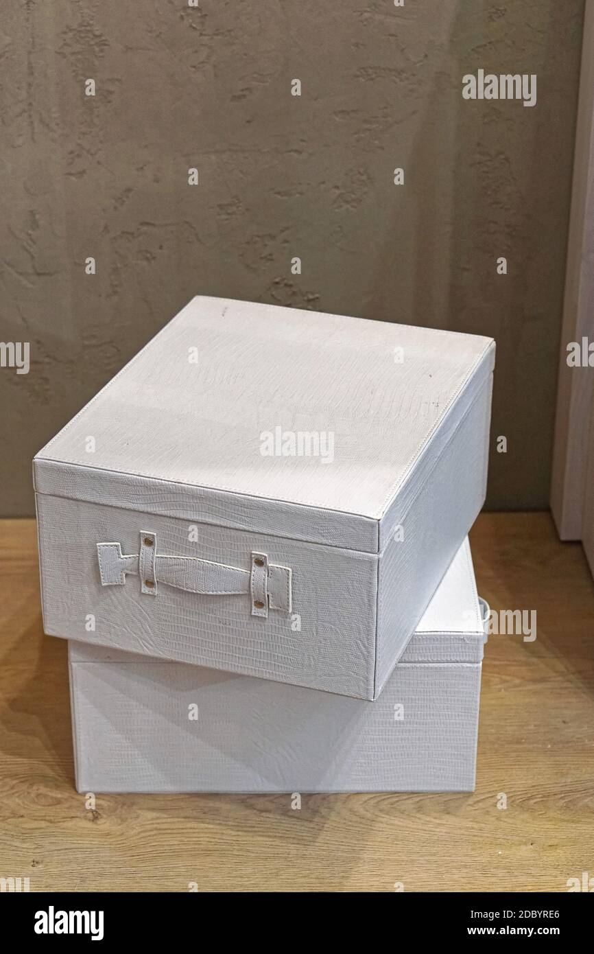 Two white boxes stacked at wooden floor Stock Photo - Alamy
