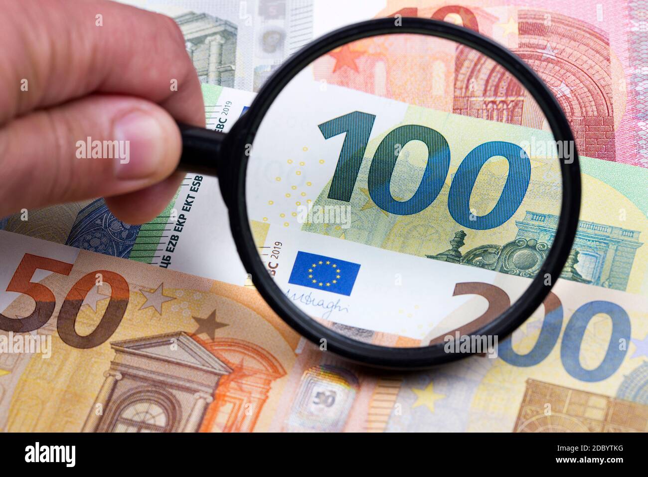 European money in a magnifying glass Stock Photo - Alamy