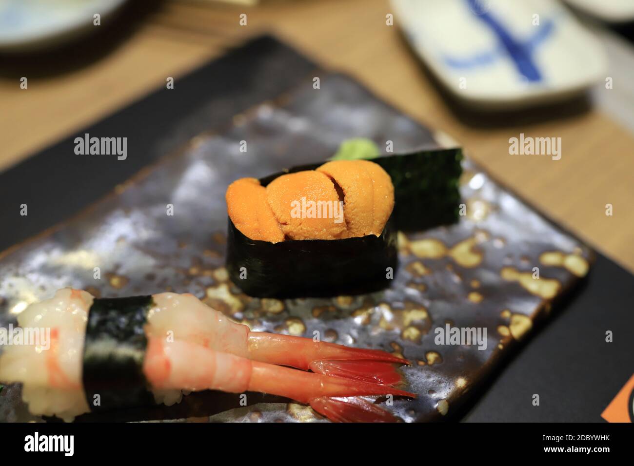 Sea urchin sushi wrapped in seaweed on a traditional Japanese dish in a ...