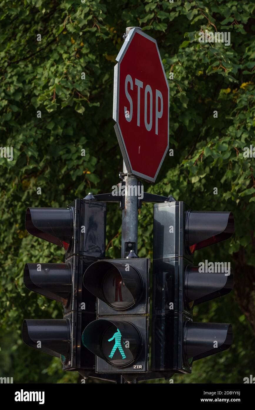 stop road sign and traffic light with a lit green signal light in the ...