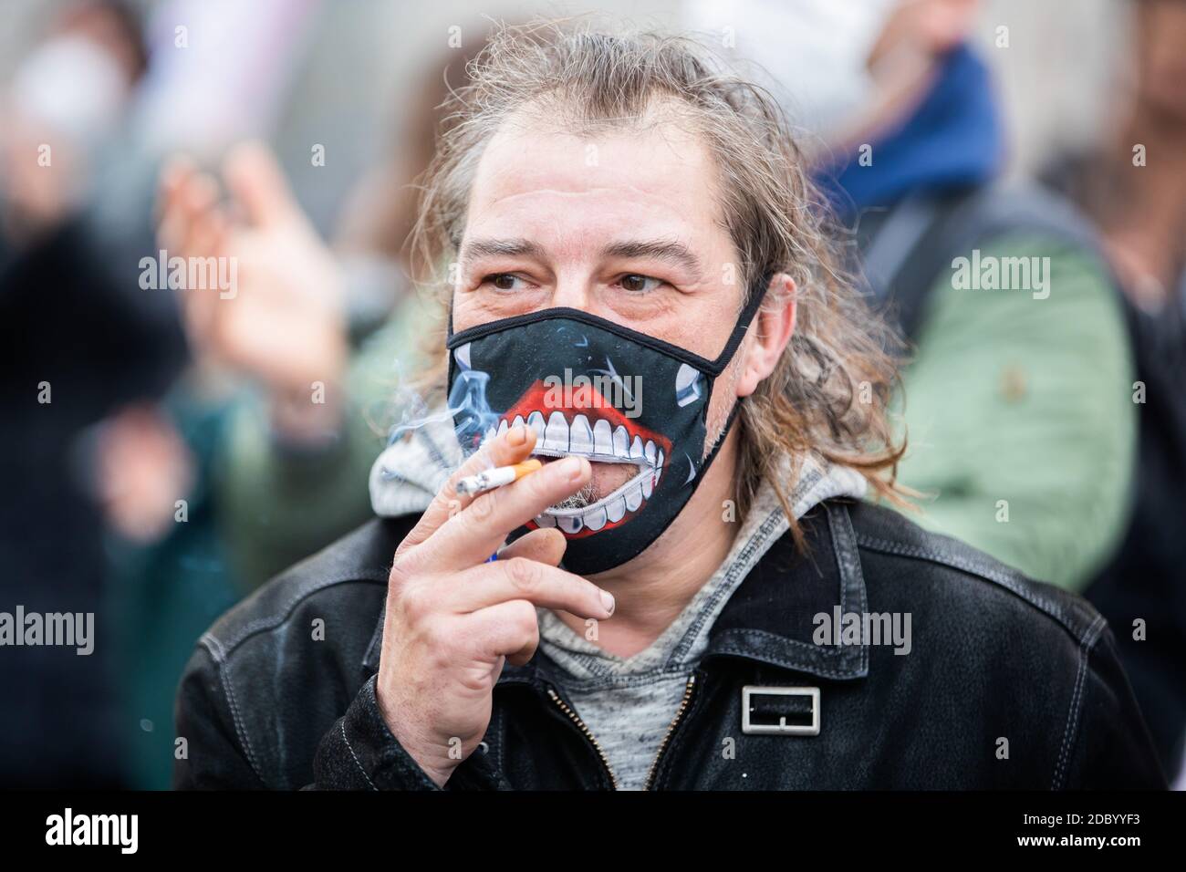 Berlin, Germany. 18th Nov, 2020. A man smokes a cigarette by covering ...