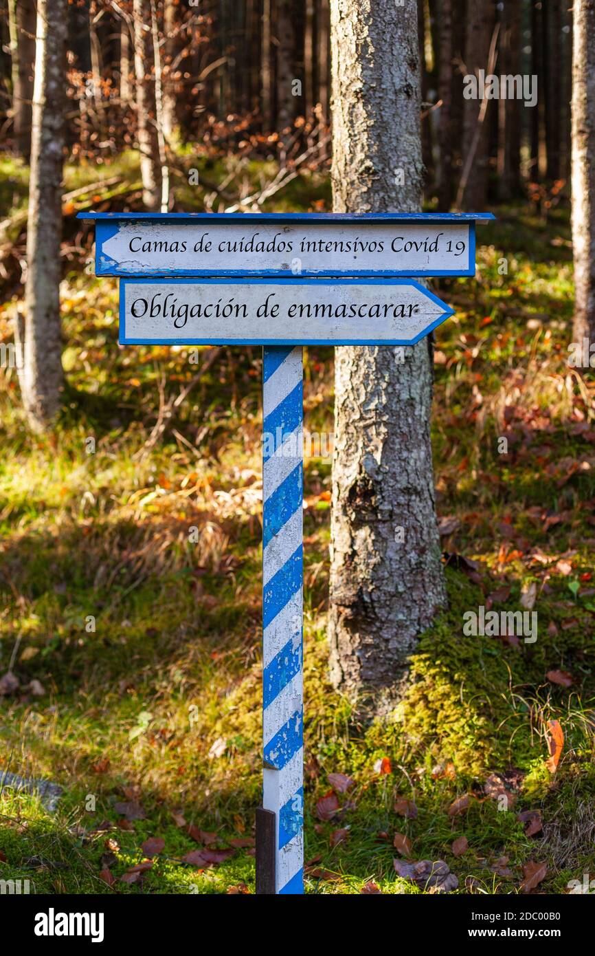 White-blue signpost indicating the direction to go. Masks compulsory or ...