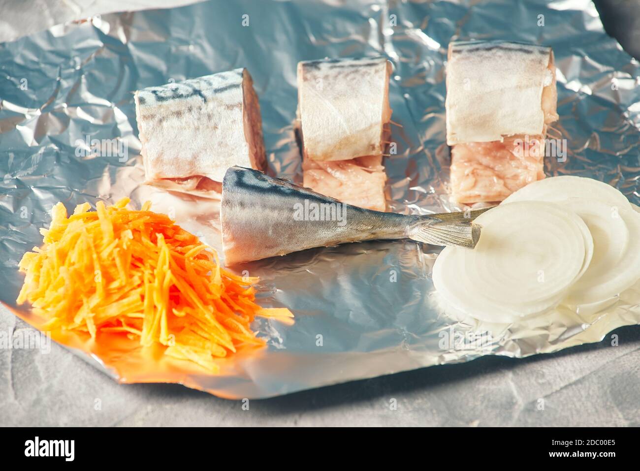 fresh sliced carrot onion fish lie on foil for baking. healthy eating ...