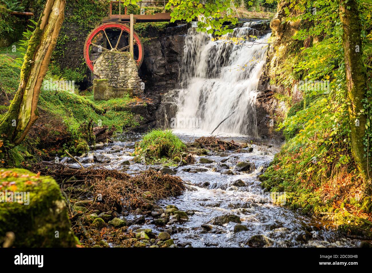 Vintage red waterwheel with waterfall in autumn colours in Glenariff ...
