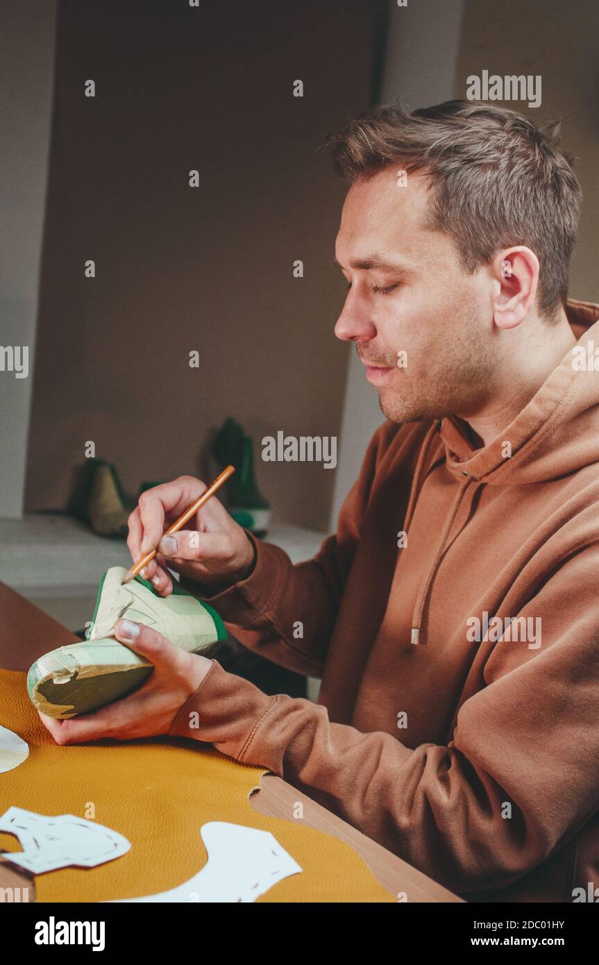 Shoemaker drawing a pattern on the shoe model Stock Photo - Alamy